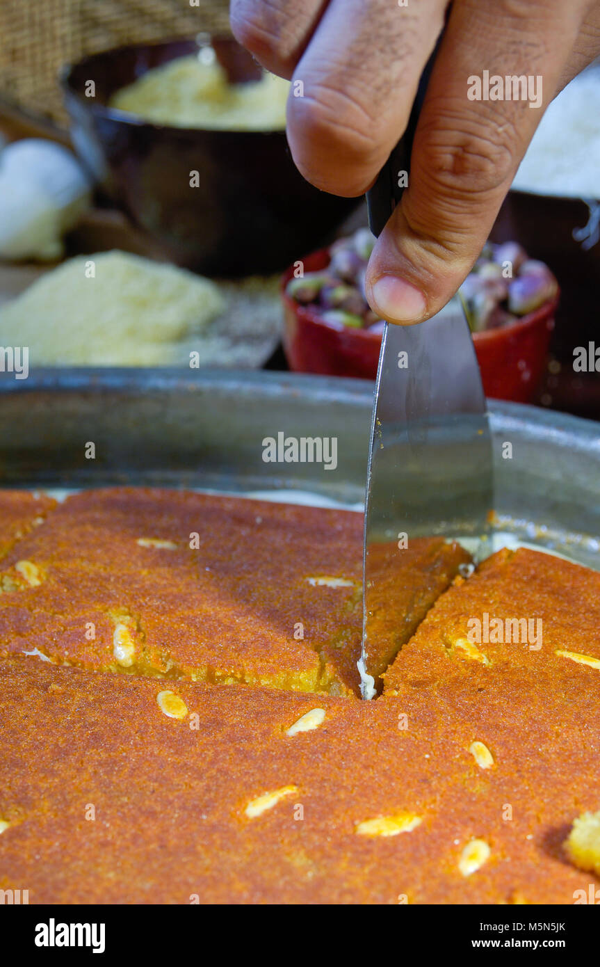 Cutting Kunfa or Kinafa, Arabic Sweets with Cheese, Nuts and Other ...