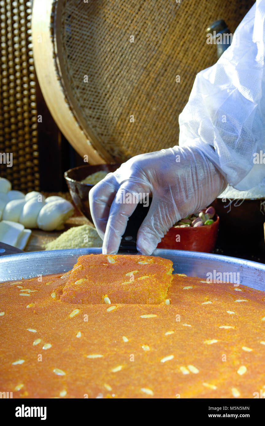 Cutting Kunfa or Kinafa, Arabic Sweets with Cheese, Nuts and Other ...