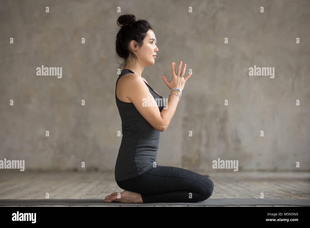 Young woman practicing yoga, doing seiza exercise, vajrasana pose ...