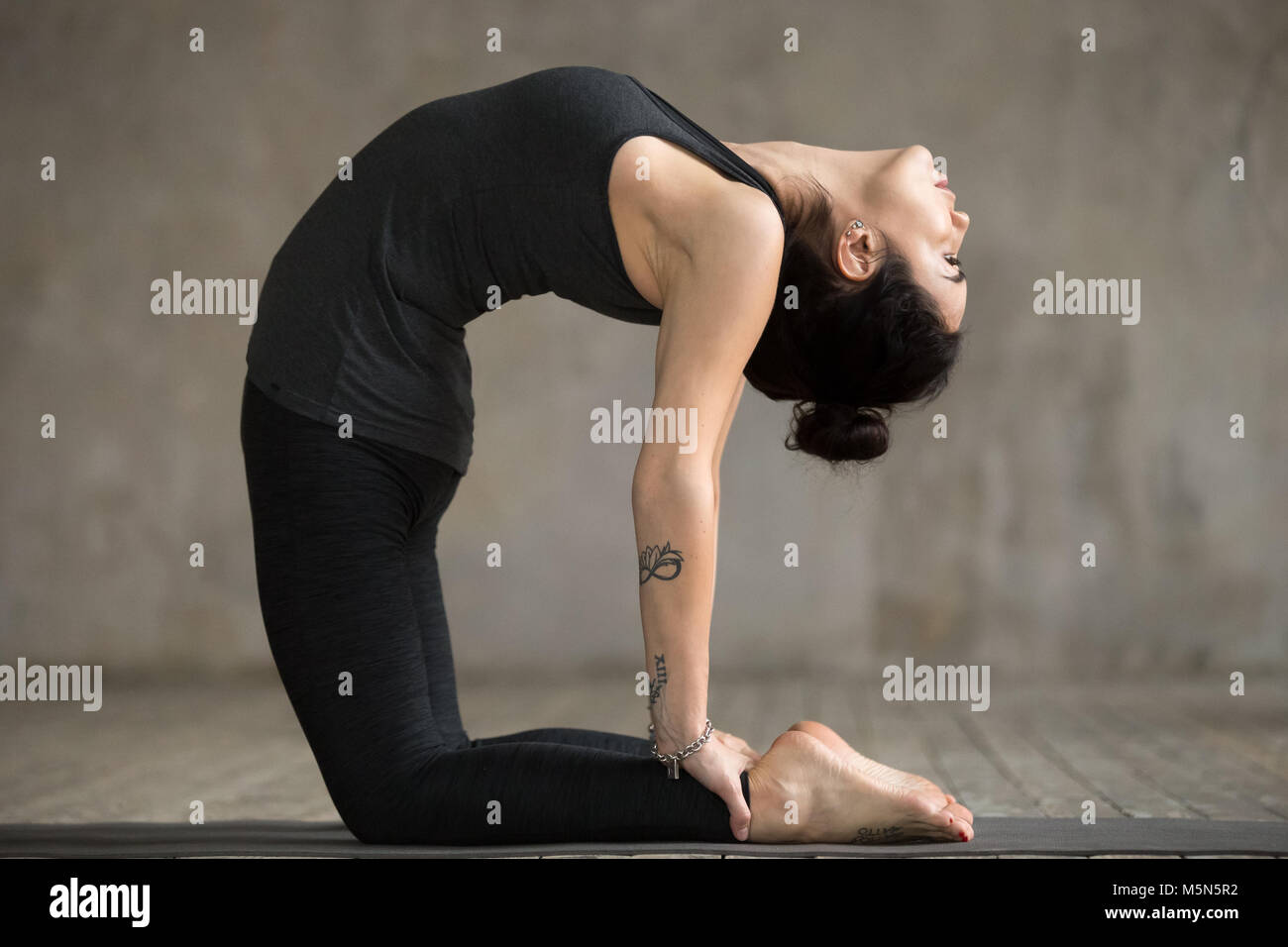 Young woman practicing yoga, doing Ustrasana exercise, Camel pose ...