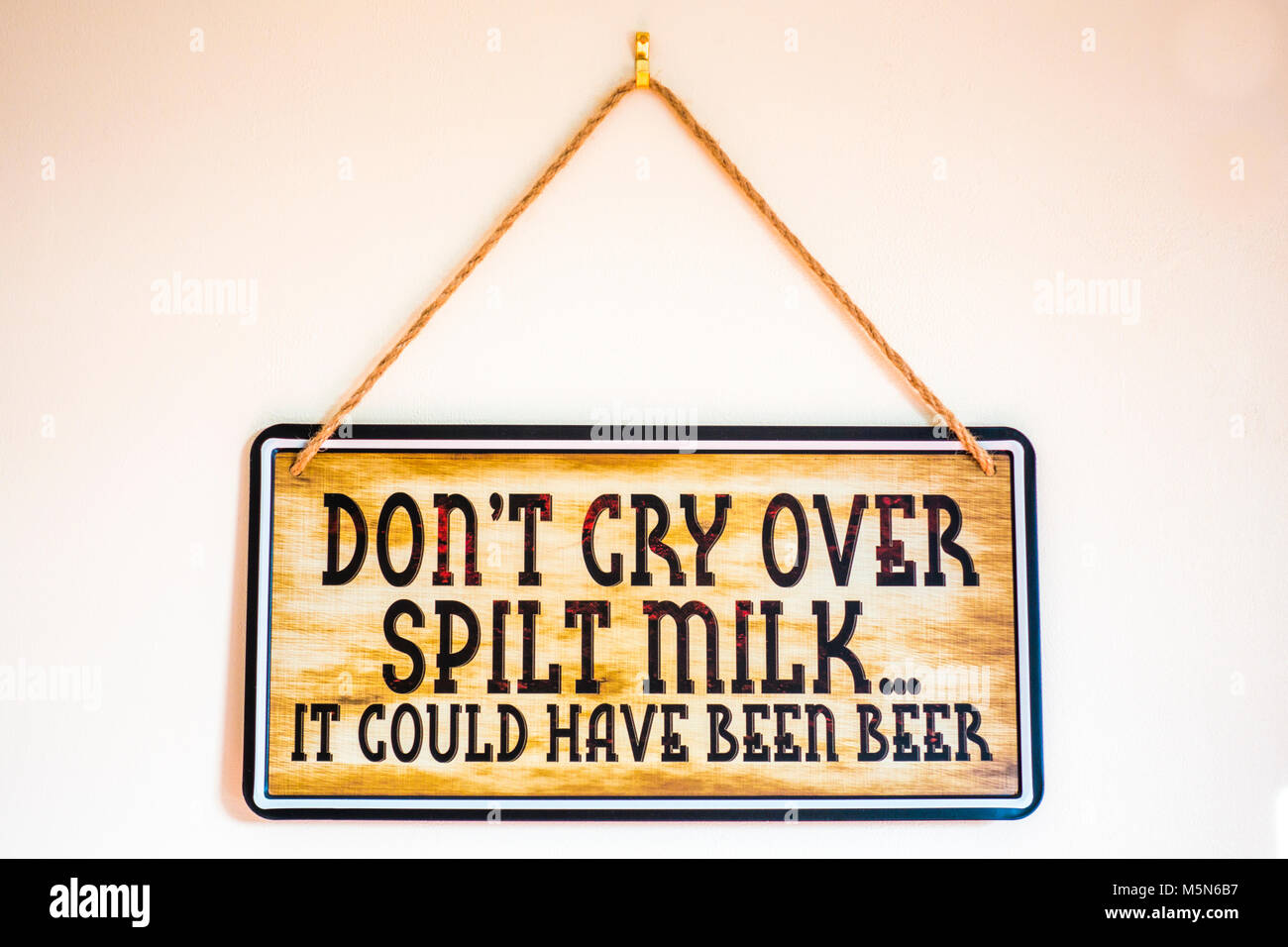 Sign hanging by string on an interior wall, bearing the witty slogan ...