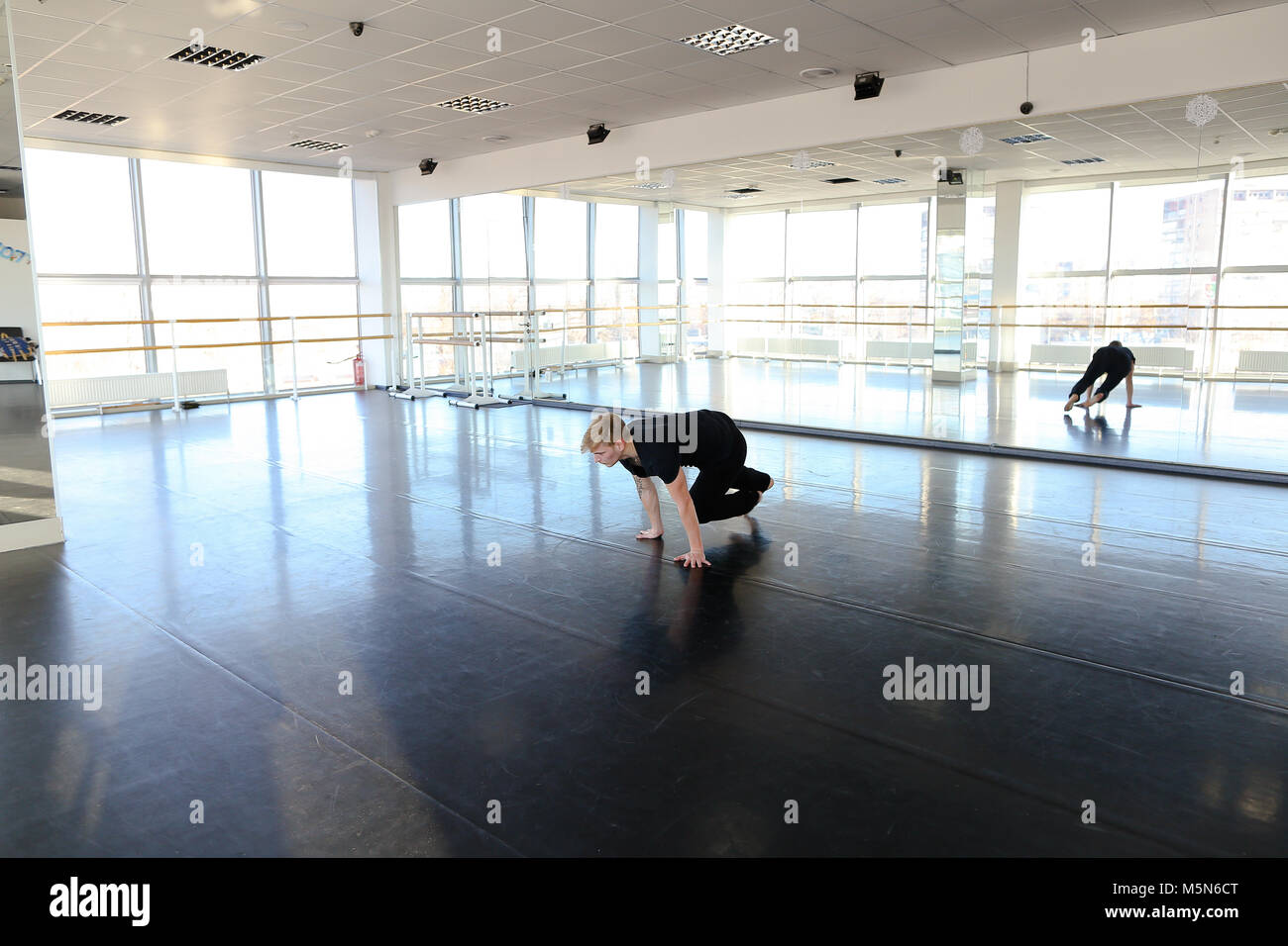 Dance trainer sitting on twine with tilts forward Stock Photo - Alamy