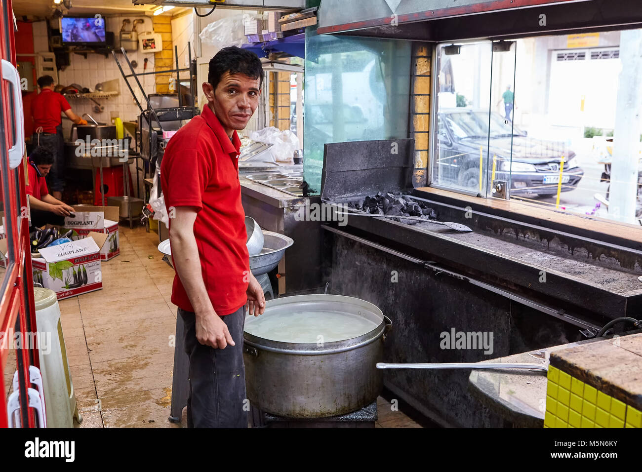 Kashan, Iran - April 25, 2017: Iranian man cooks food in a large pan in ...