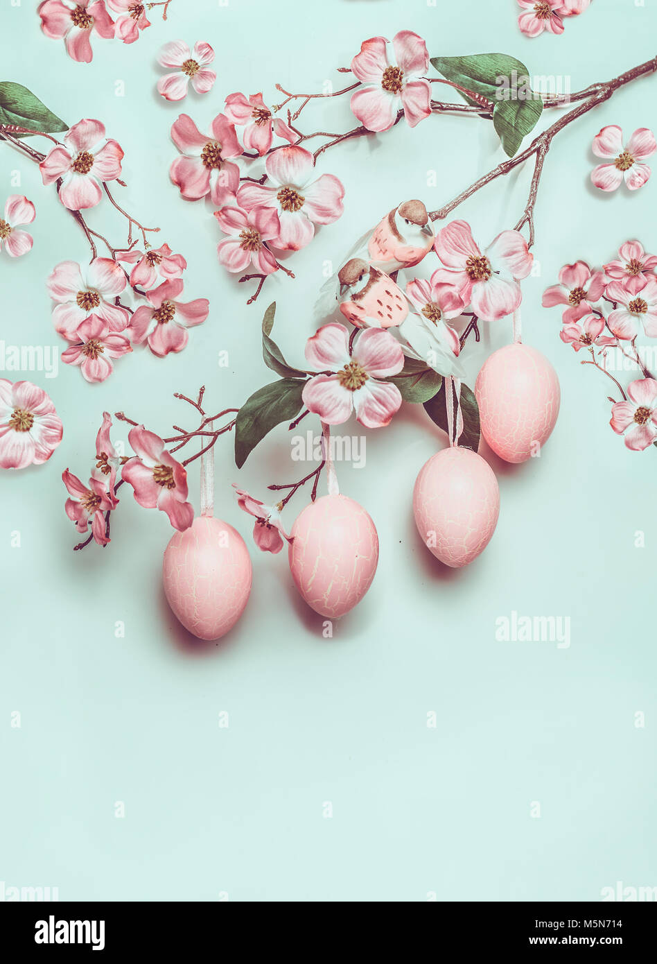 Easter pastel pink layout with hanged eggs and decor blossom on ...