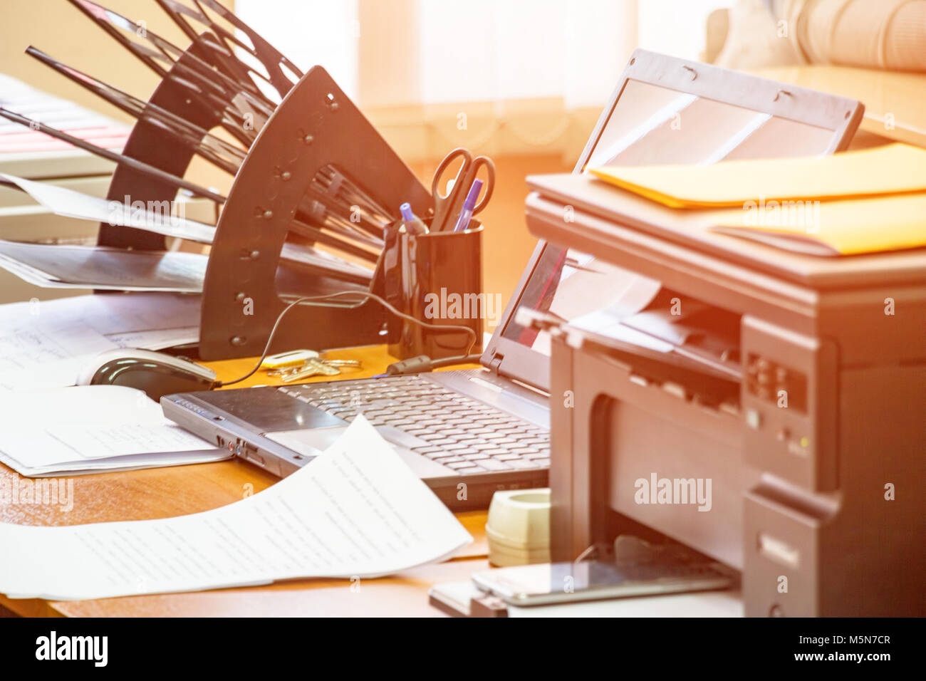 Office workplace with laptop, printer, stand for papers and business ...