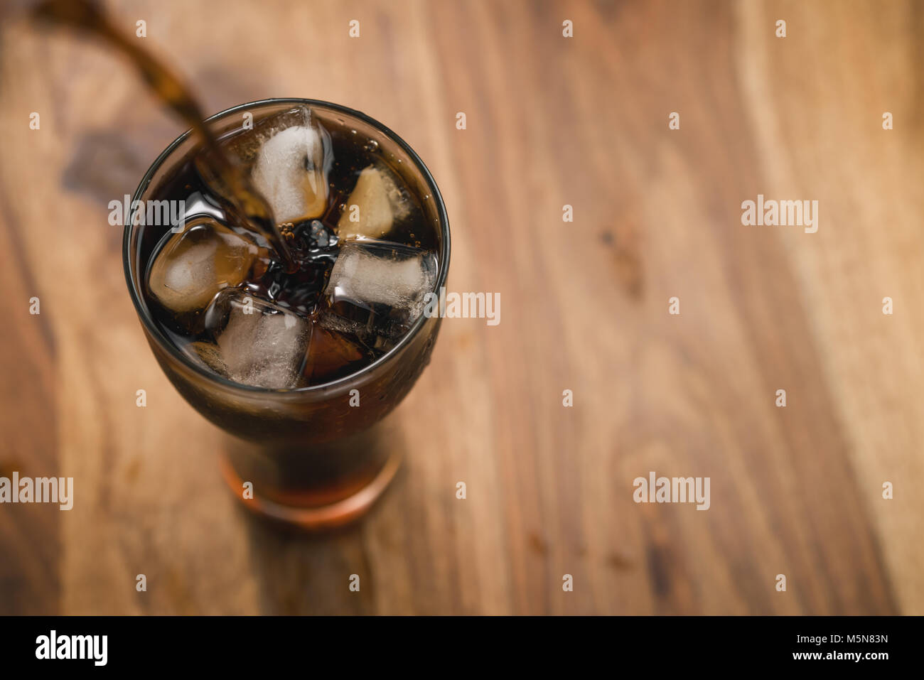 top view pour cola in gto glass on wood table with copy space, shallow ...