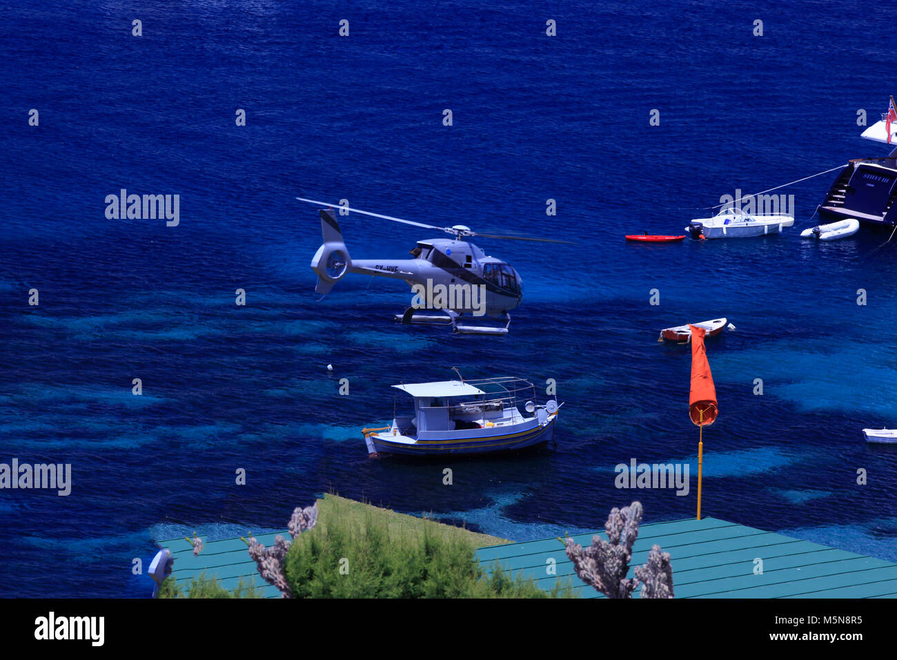A helicopter in the blue sky in Mykonos, Greece Stock Photo - Alamy