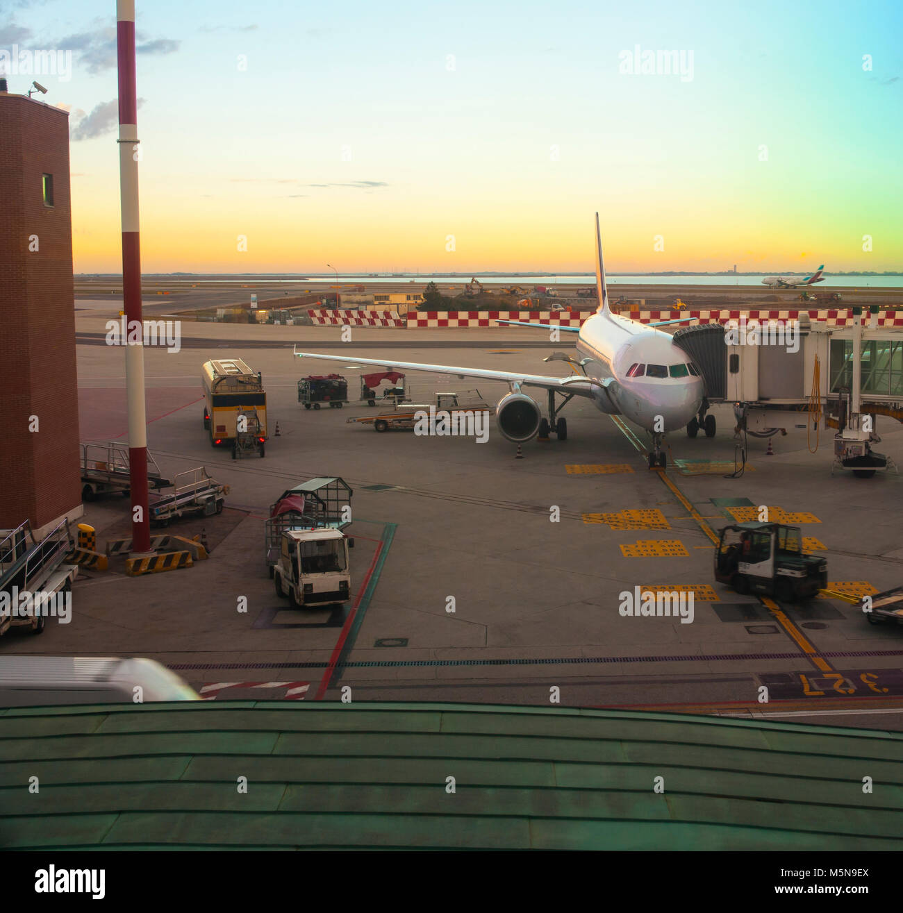 Airplane at the terminal gate ready for takeoff at sunset Stock Photo ...