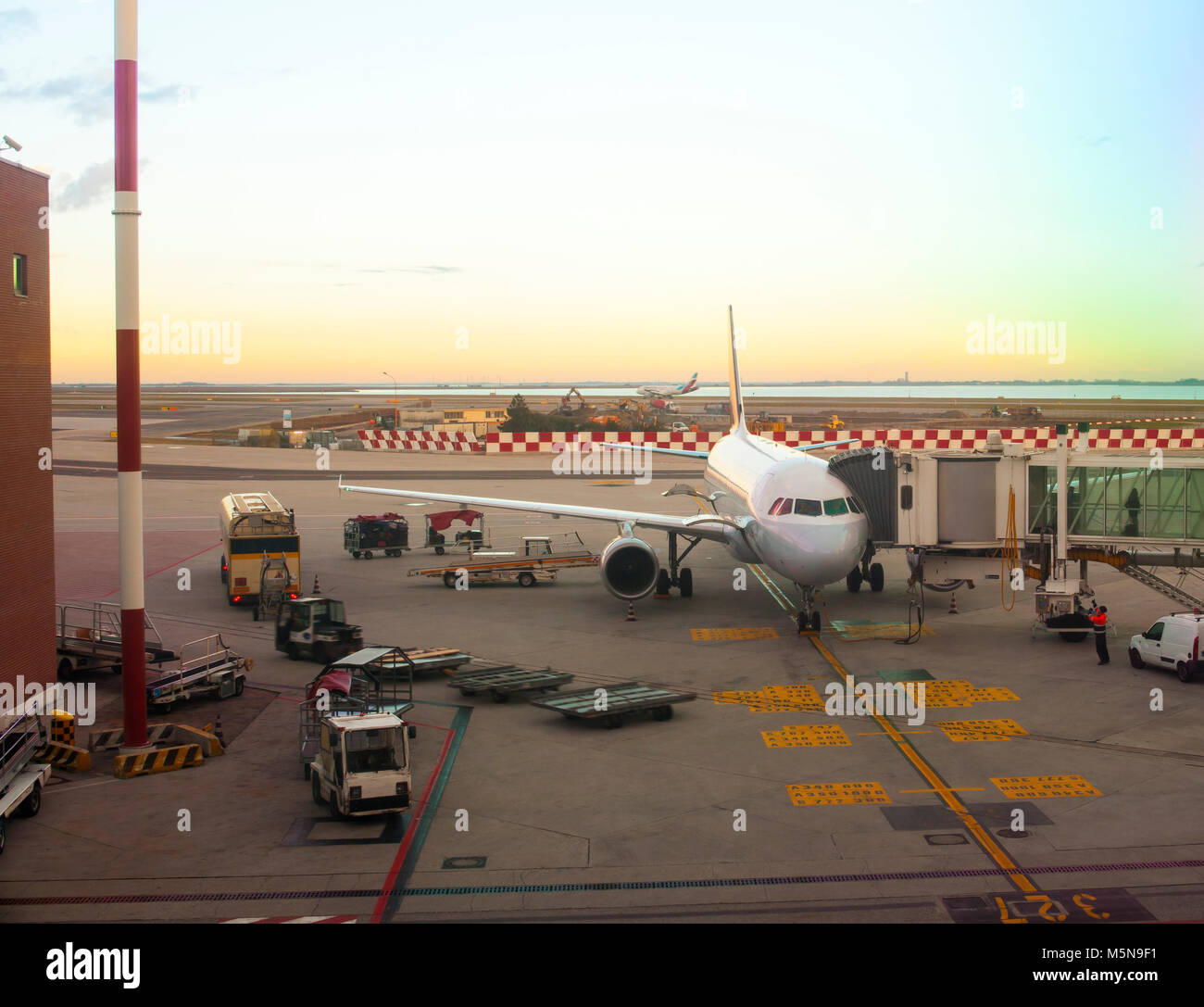 Airplane at the terminal gate ready for takeoff at sunset Stock Photo ...