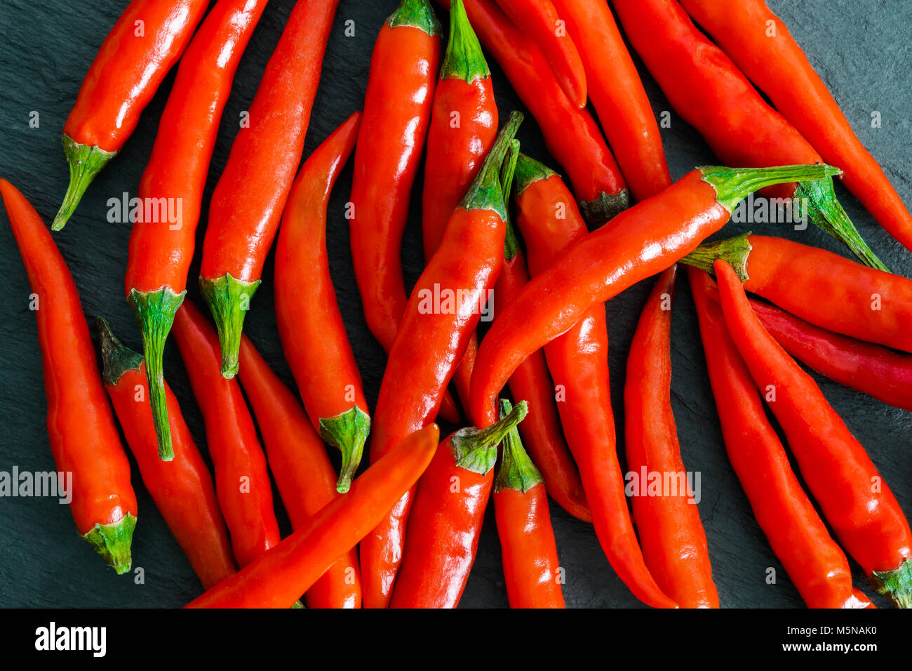 Chili peppers background on black rock surface Stock Photo - Alamy