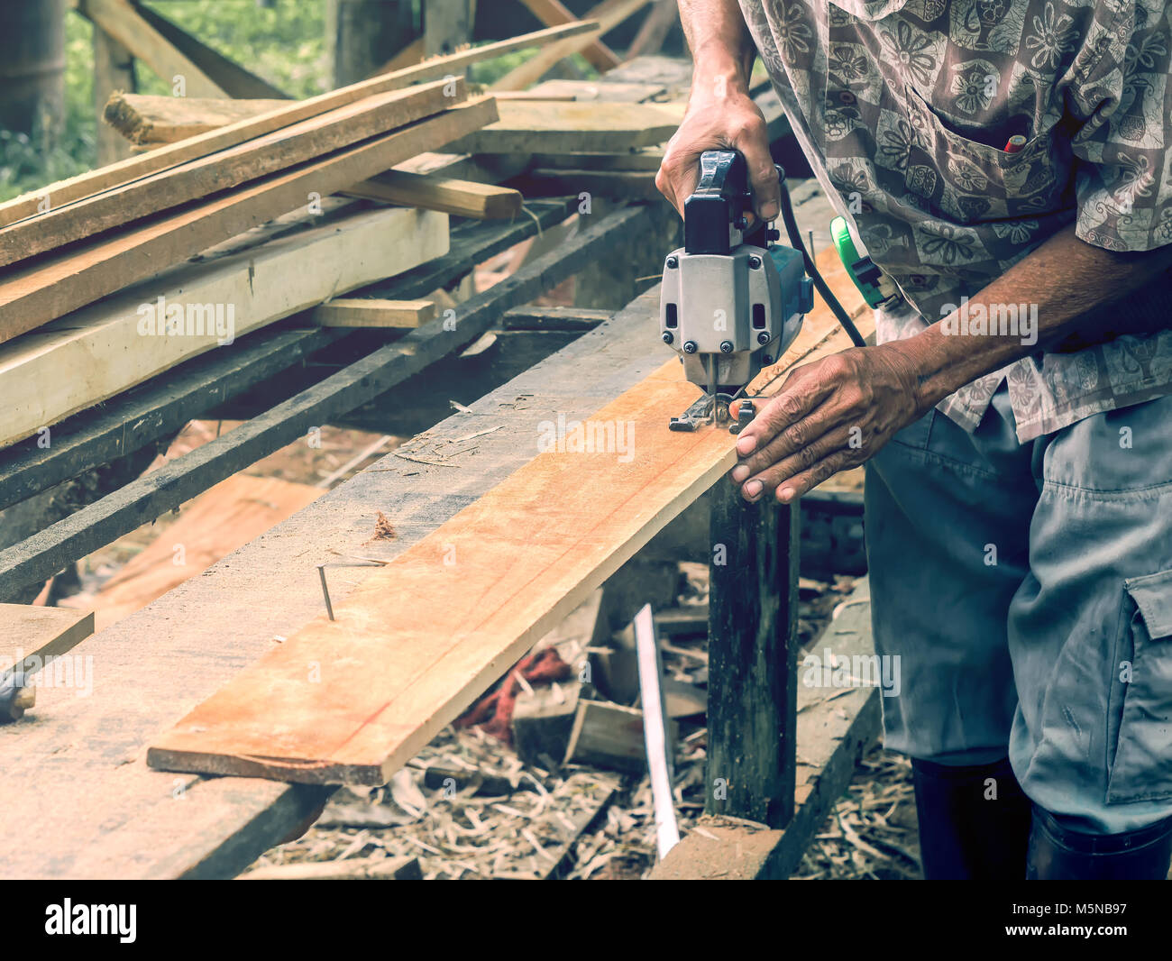 Carpenter cutting wooden panel by using jig saw Stock Photo - Alamy
