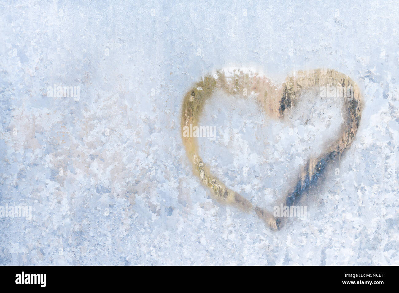 Heart on a frosty winter in the frozen patterns of ice window Stock ...