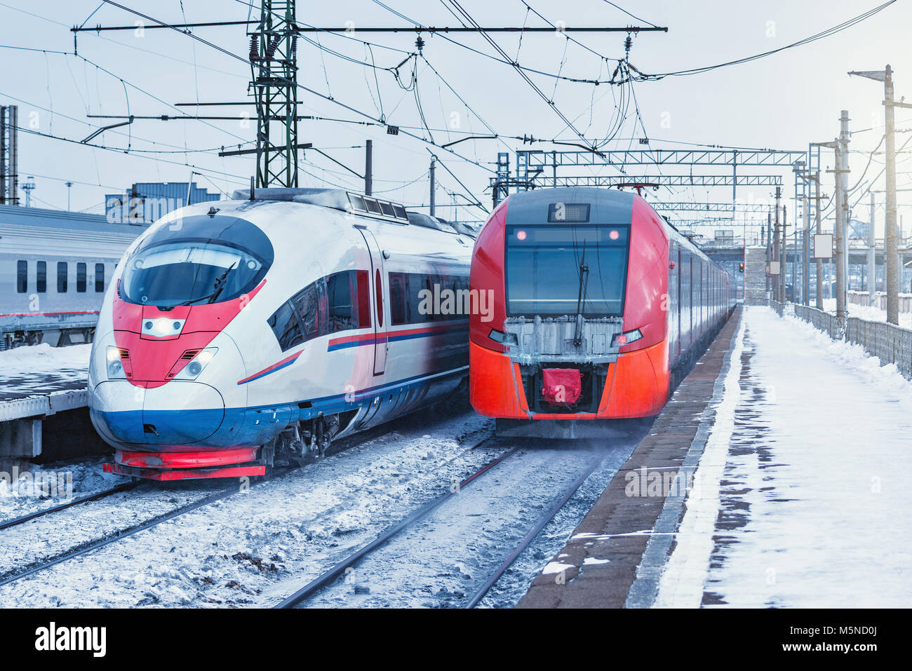 Two modern high-speed trains moves fast at winter day time Stock Photo ...