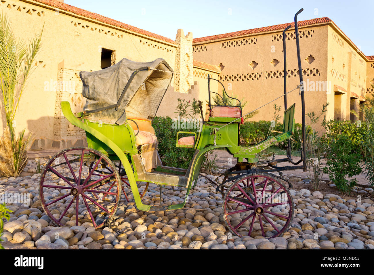 Old carriage standing on a garden in the desert Stock Photo - Alamy