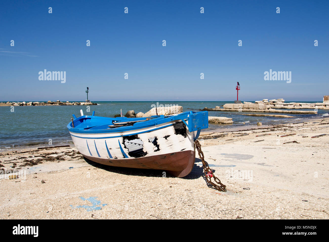 Little blue burnt boat on the beach Stock Photo - Alamy