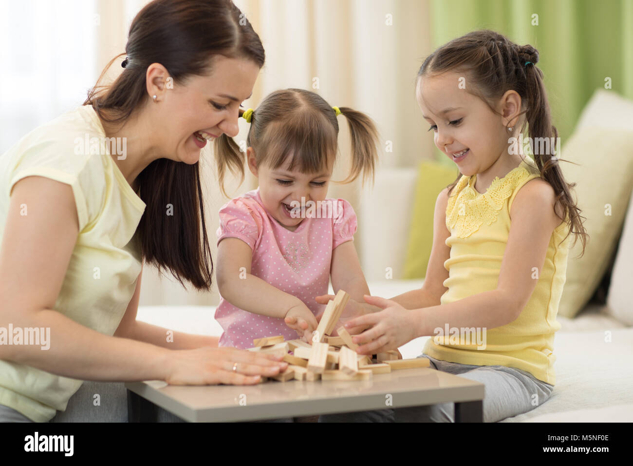 Family at the table playing board game Stock Photo - Alamy