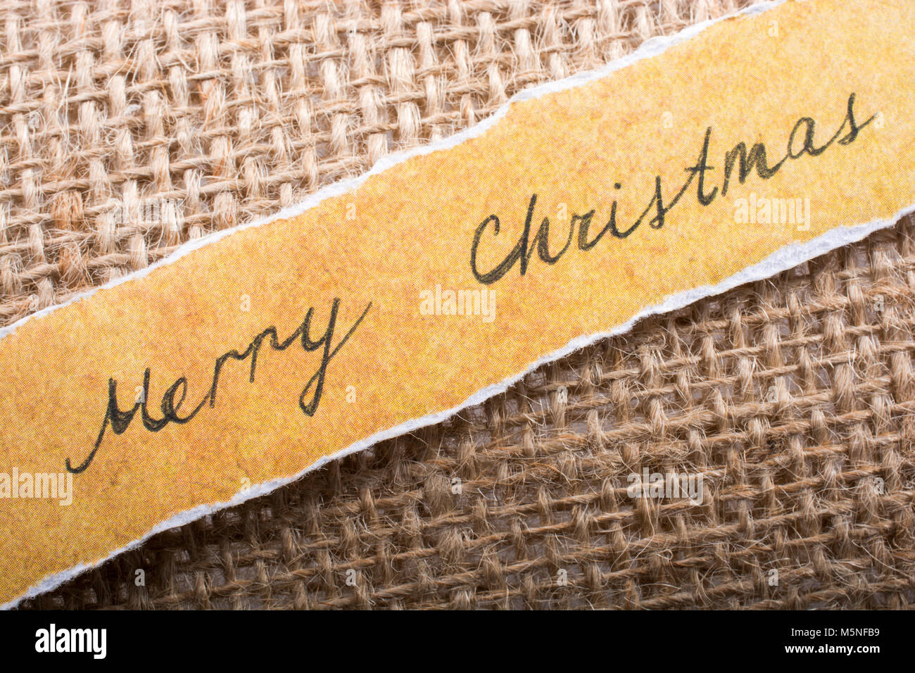 Merry Christmas wording written on a torn paper on canvas Stock Photo ...