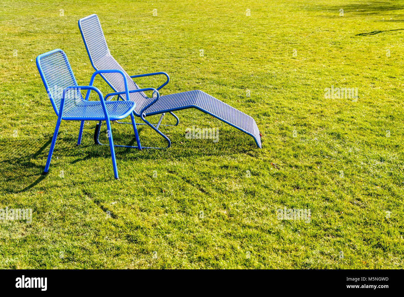 big and small blue chair on green grass Stock Photo - Alamy