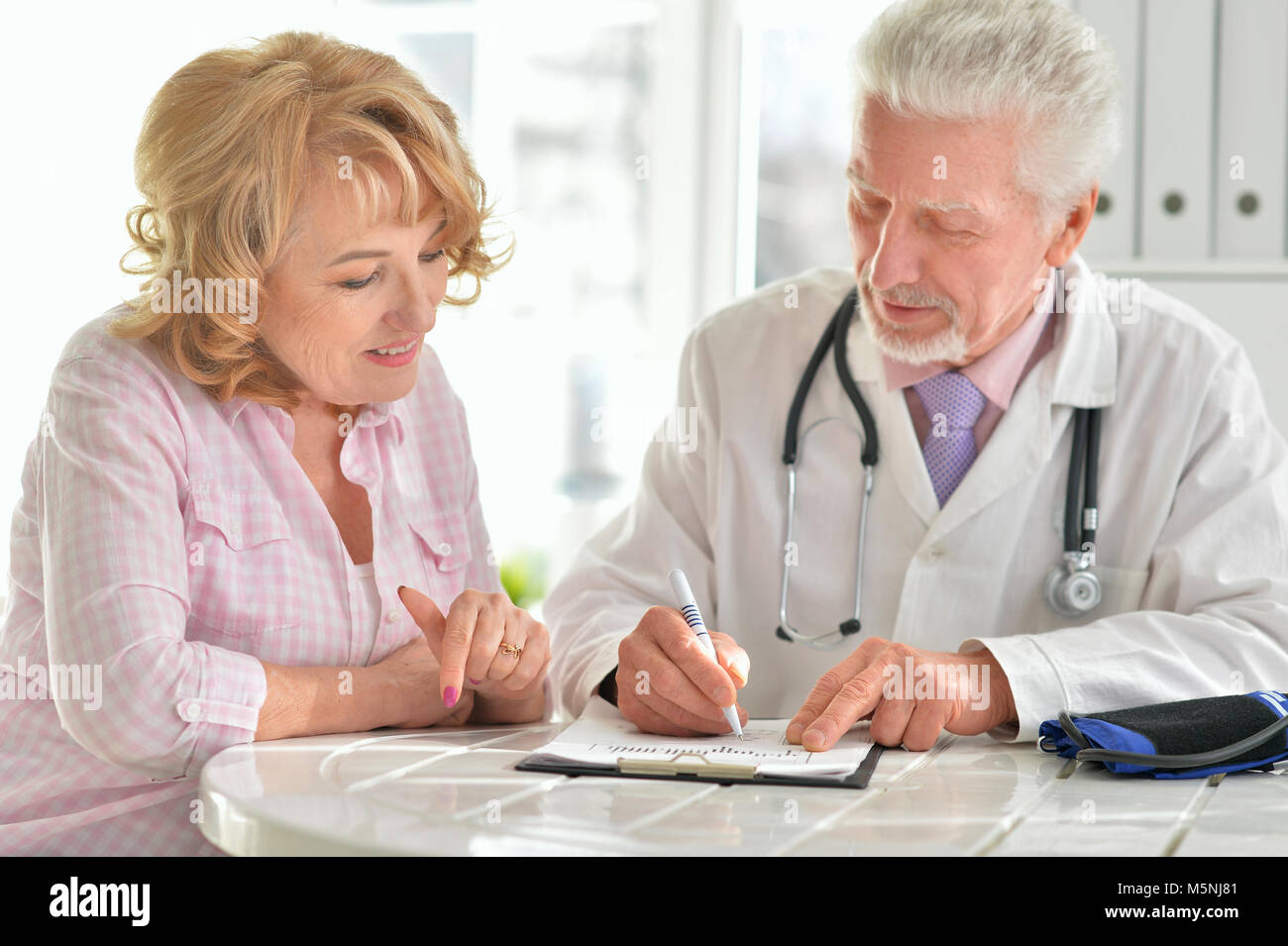 Senior doctor with elderly patient Stock Photo - Alamy