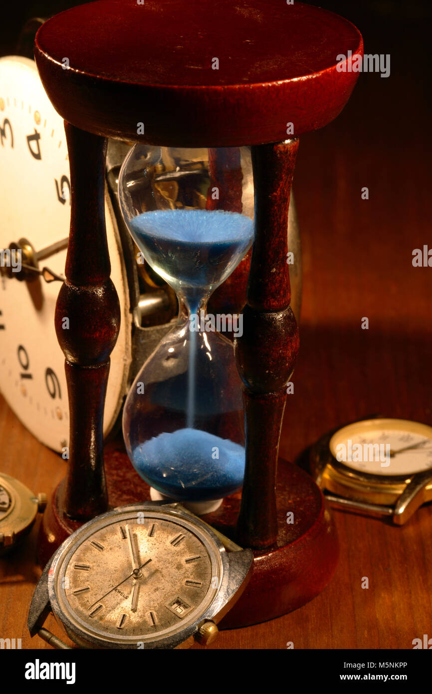 Hourglass, old watch and clock mechanism on wooden background Stock ...
