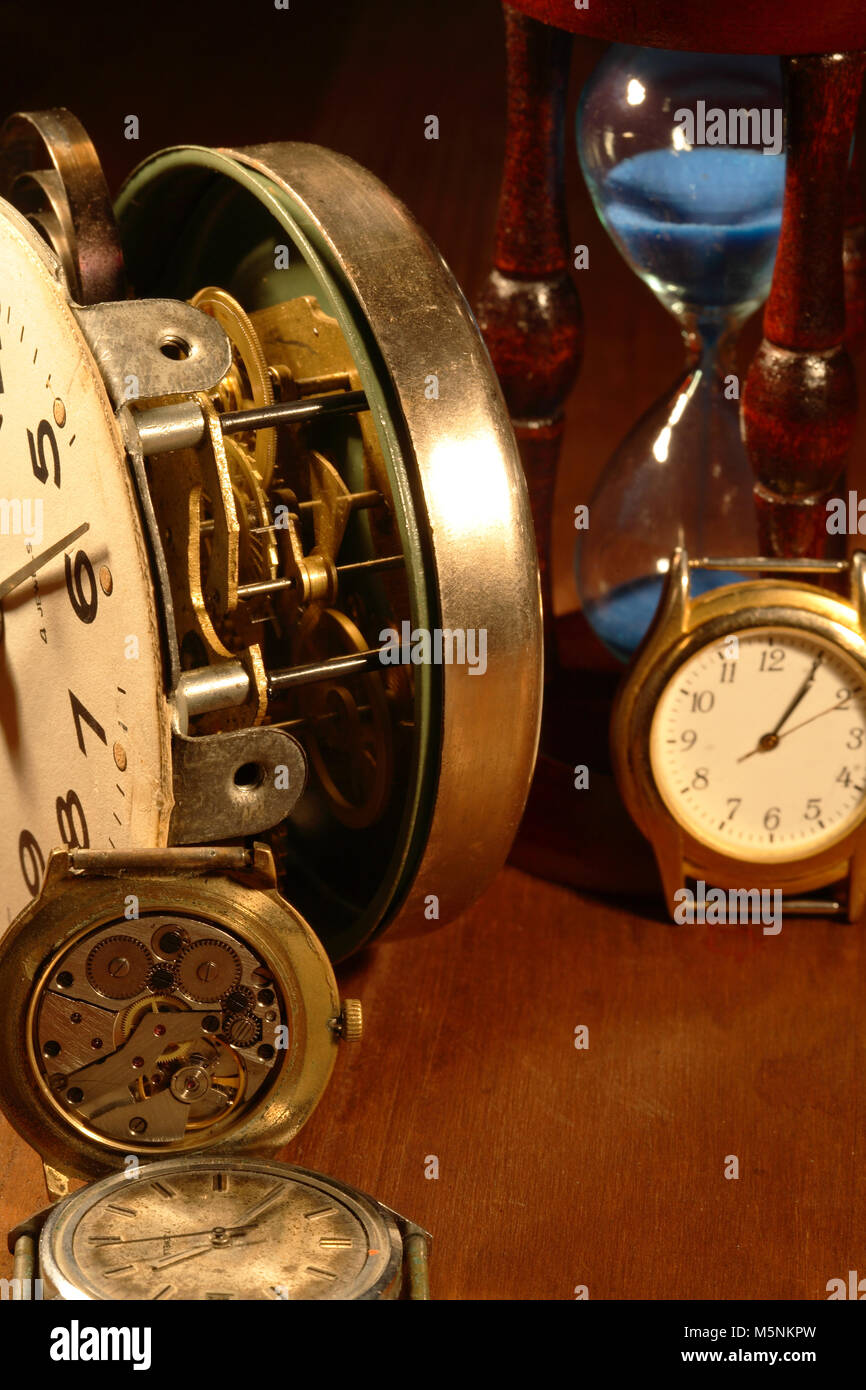 Hourglass, old watch and clock mechanism on wooden background Stock ...