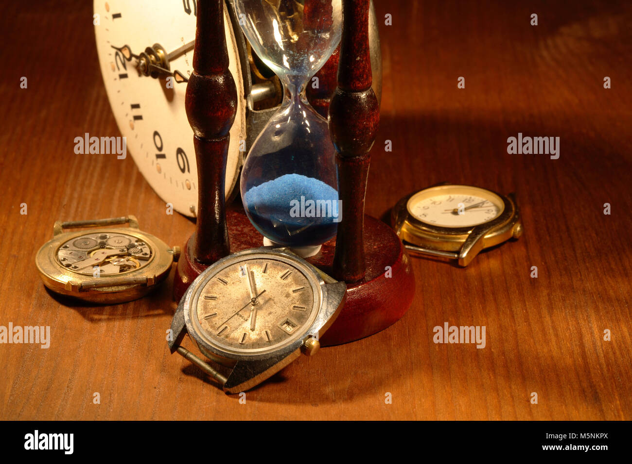 Hourglass, old watch and clock mechanism on wooden background Stock ...