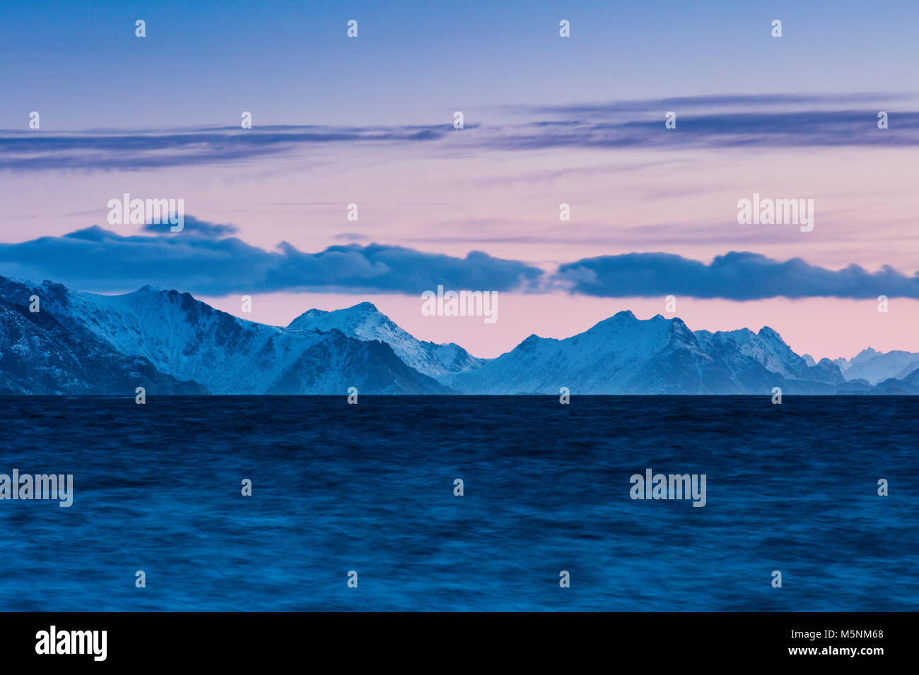 Pre-dawn sky and clouds over distant mountains and ocean Stock Photo ...
