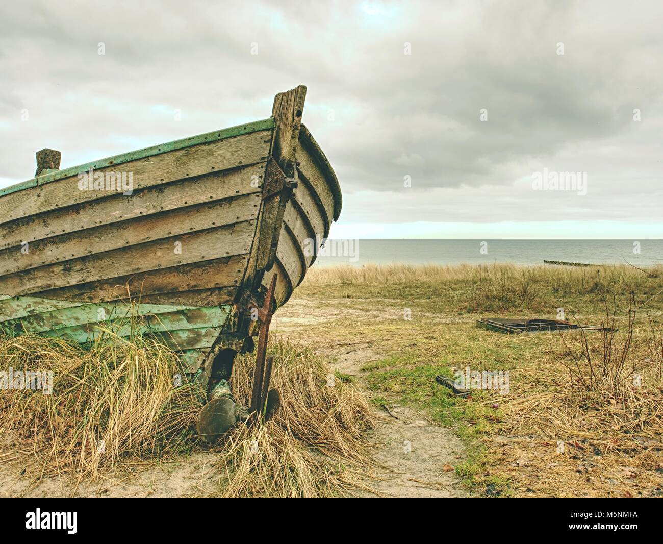 Wrecked wooden fisher boat. Broken abandoned boat in sand of sea bay ...