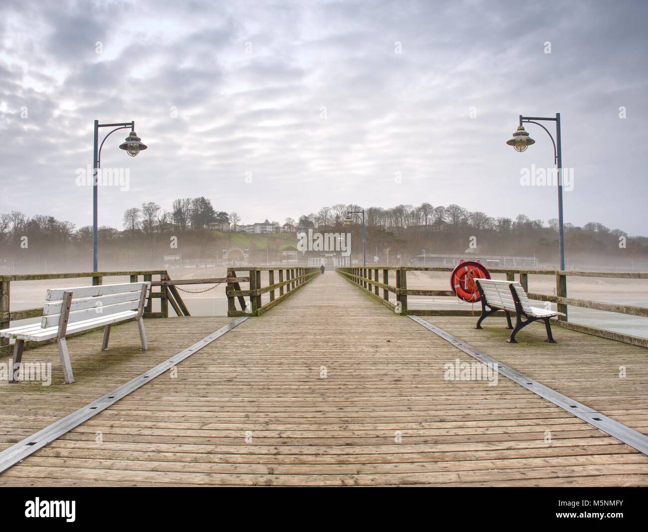 Misty dusk on the landmark fishing pier, wooden pier railings. Wooden ...