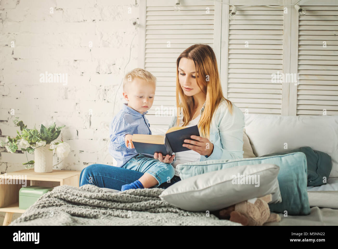 Pretty Young Mother Reading a Book to her Son. Mom and Child Reading ...