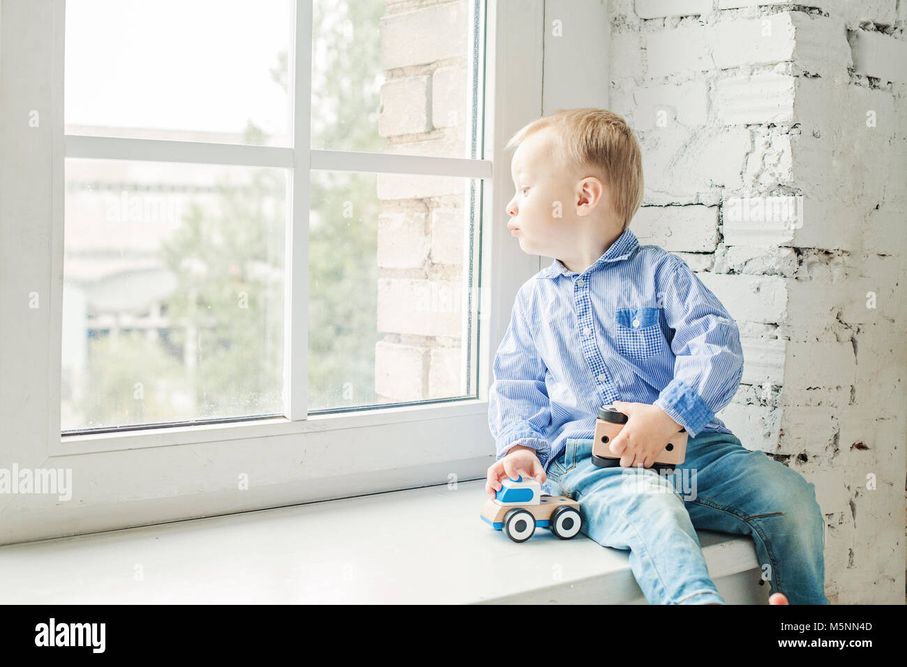 Funny child boy looking out Window at home Stock Photo - Alamy