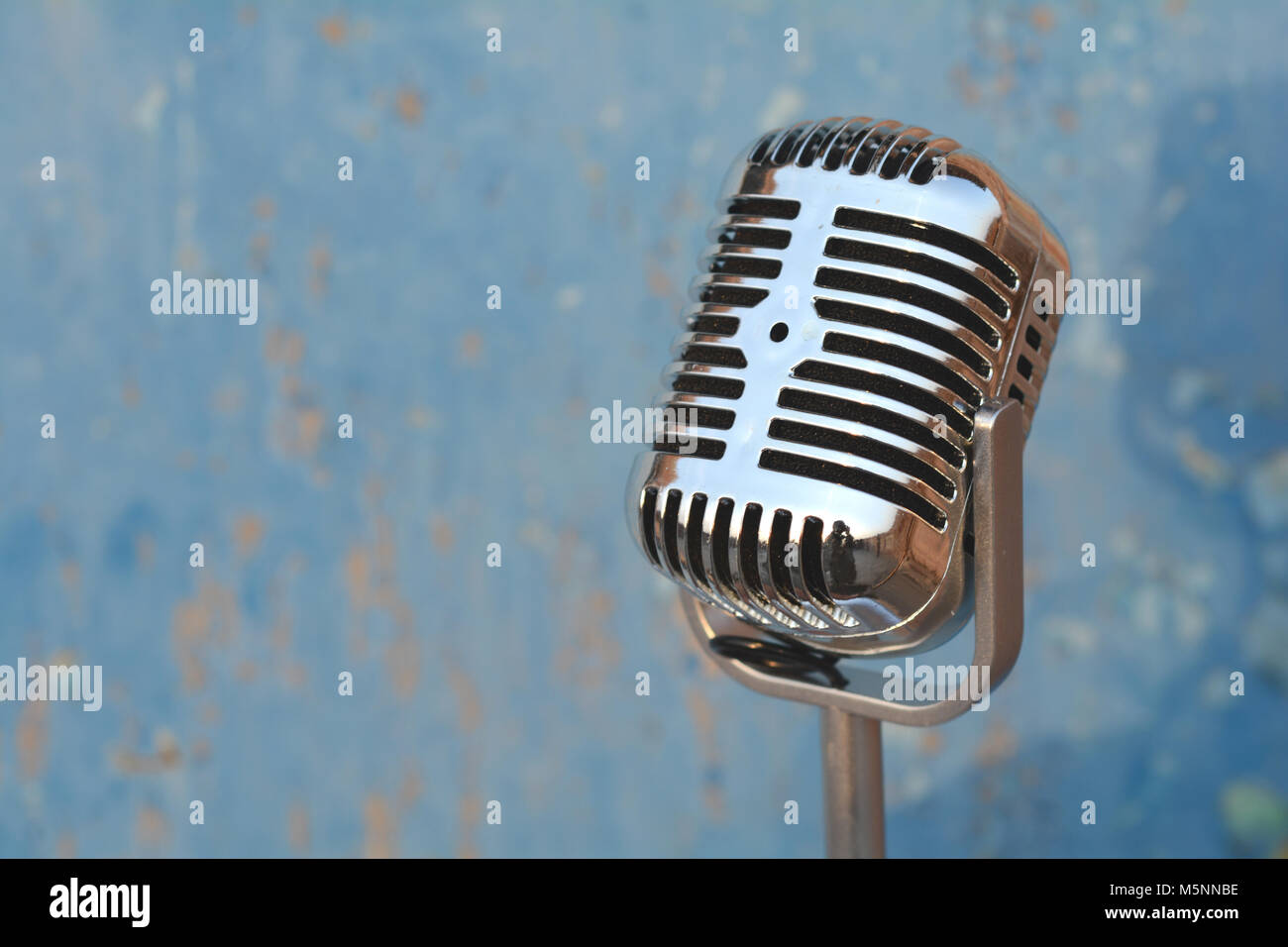 Vintage fashion metal microphone on blue wall background Stock Photo ...