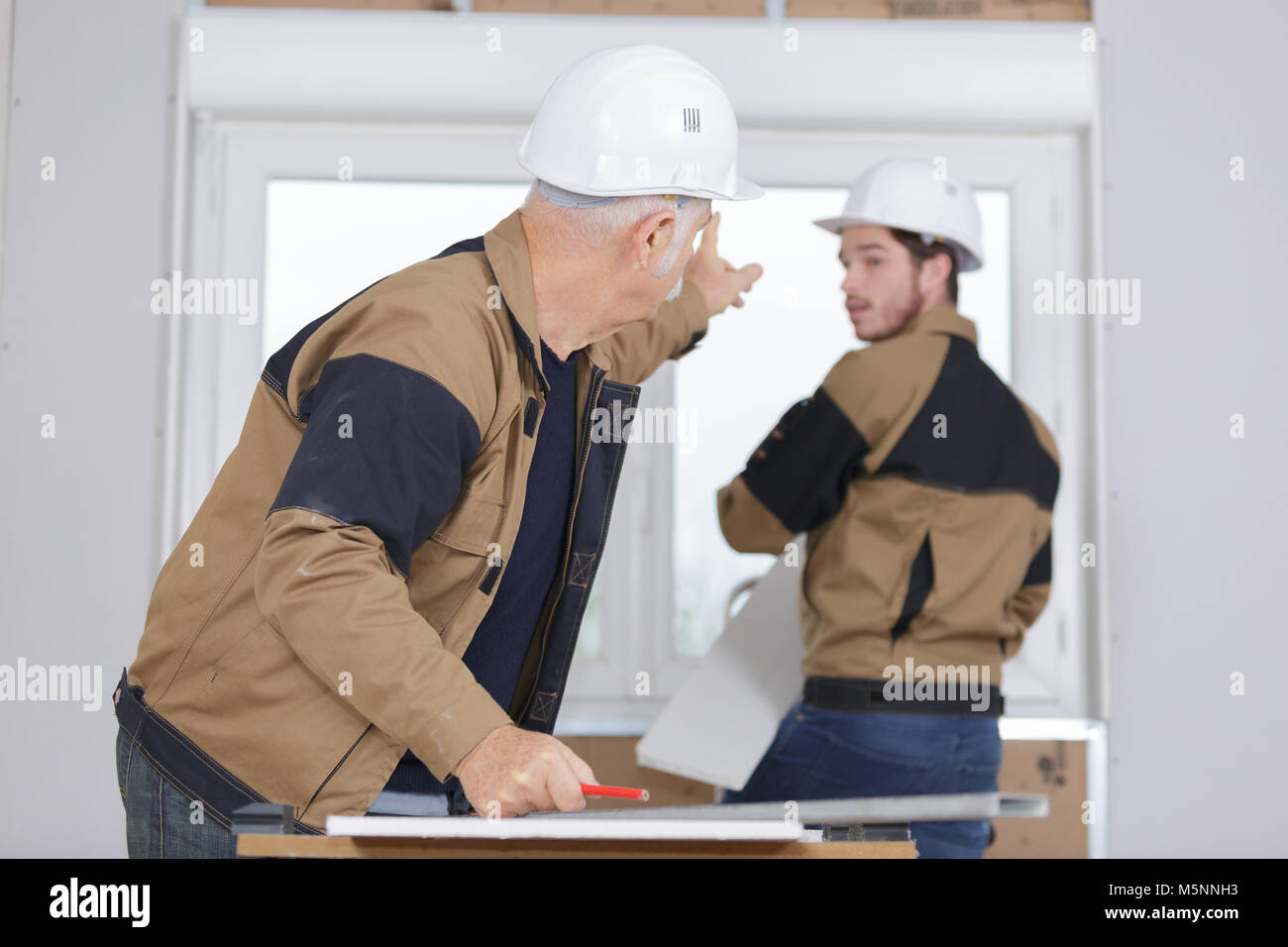 young apprentice helping in window installation Stock Photo - Alamy