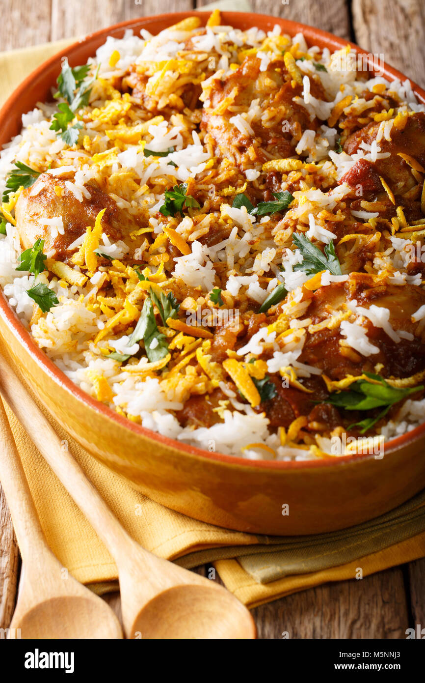 Asian biryani with chicken, spices and herbs close-up on the table ...
