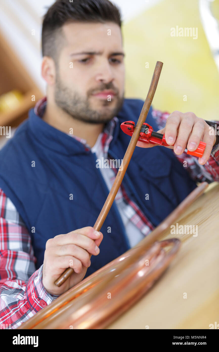 man cutting pipes for water system at construction site Stock Photo - Alamy