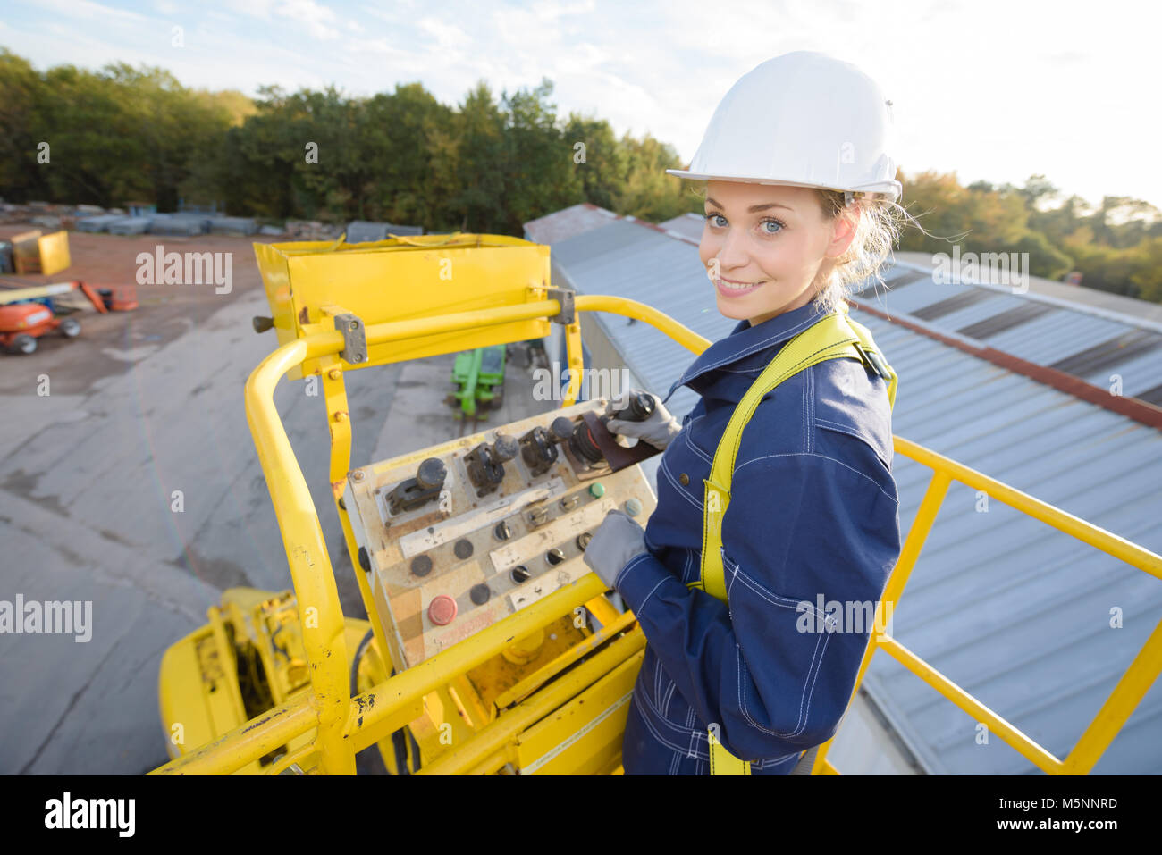 Portrait of woman elevated in cherry picker bucket Stock Photo - Alamy