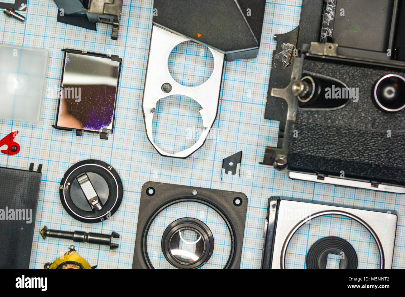 parts are completely disassembled old retro film SLR camera on graph ...