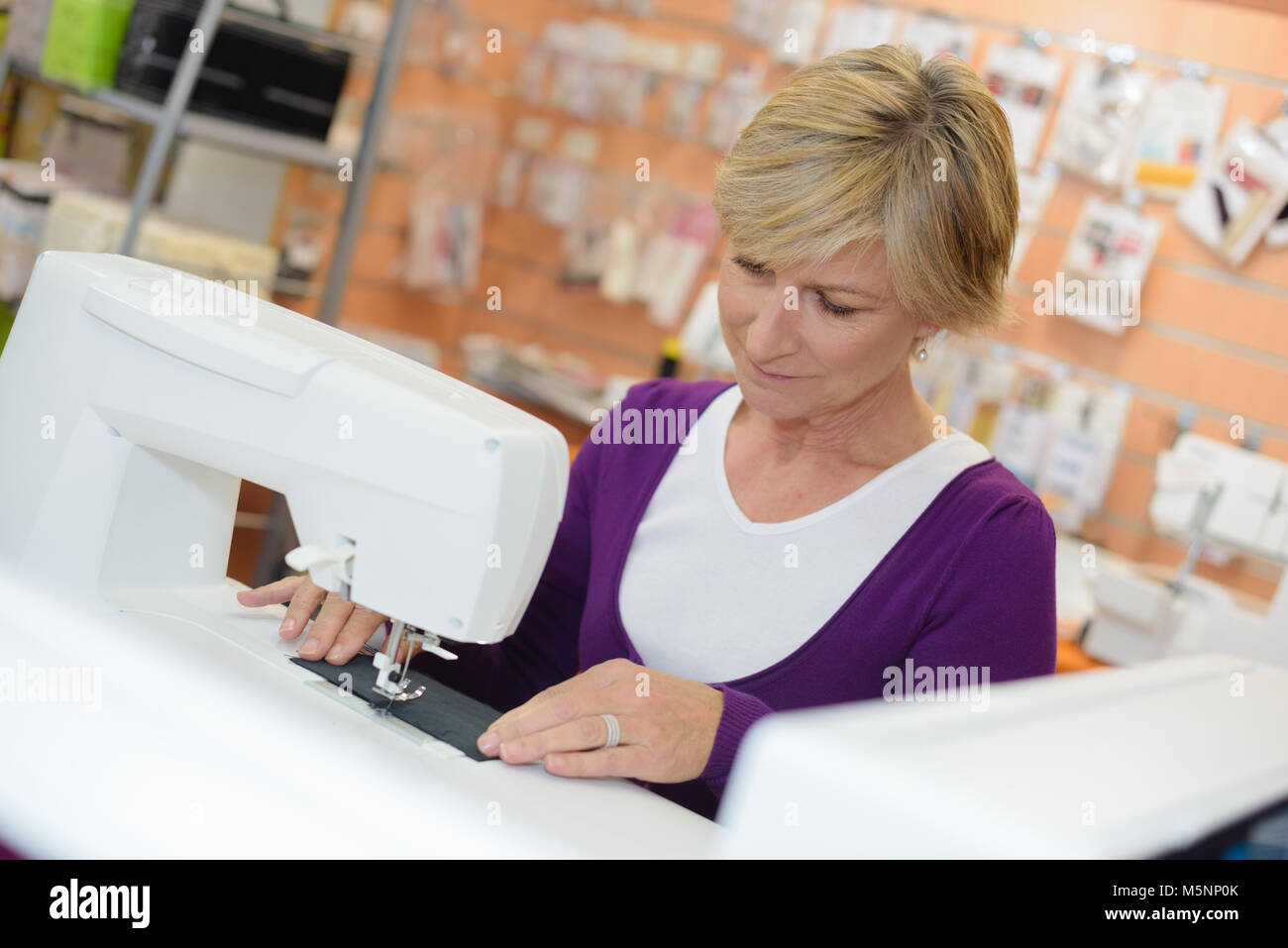 Senior lady using sewing machine Stock Photo - Alamy