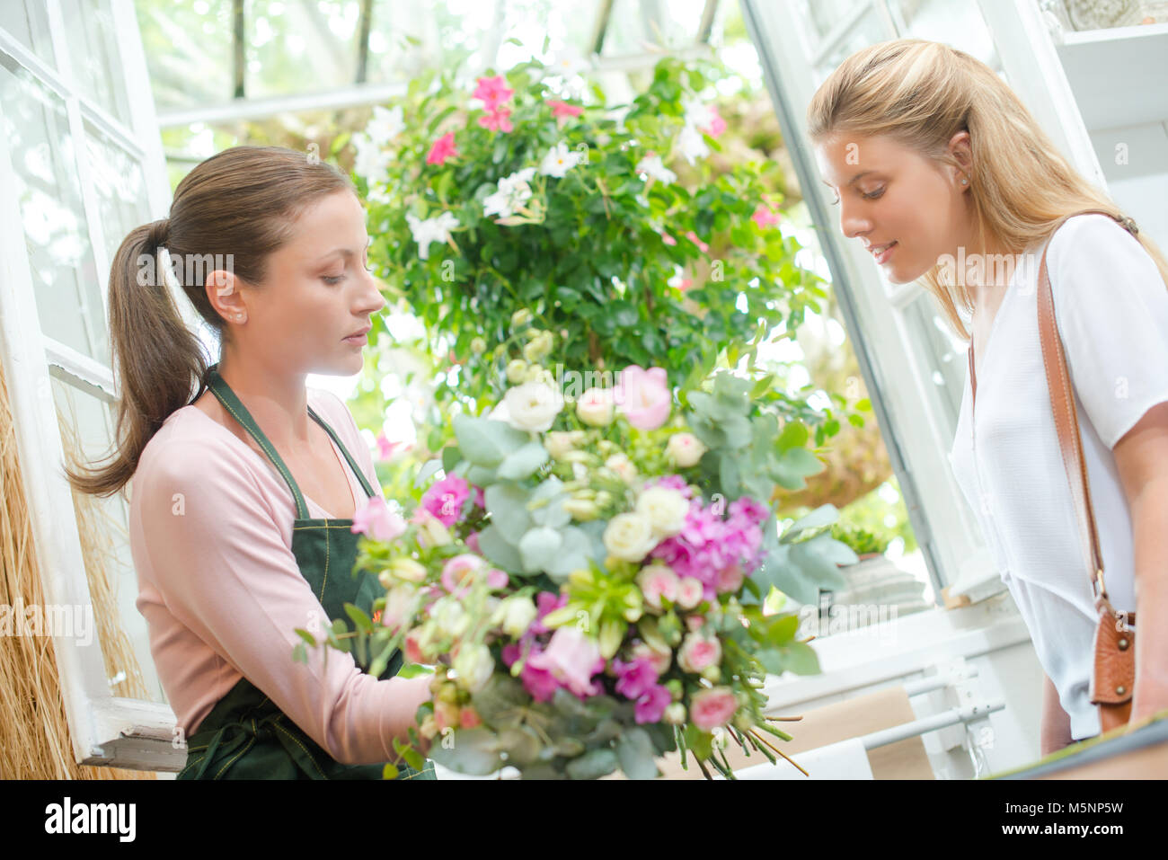 Florist presenting bouquet to customer Stock Photo - Alamy