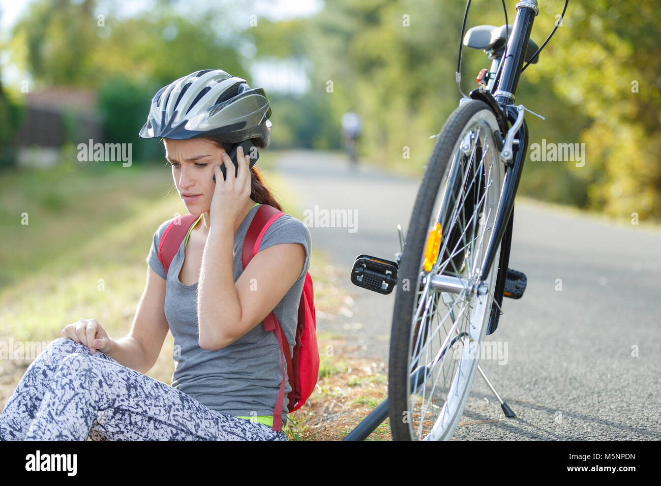 woman trying to fix bike problem calling a friend Stock Photo - Alamy
