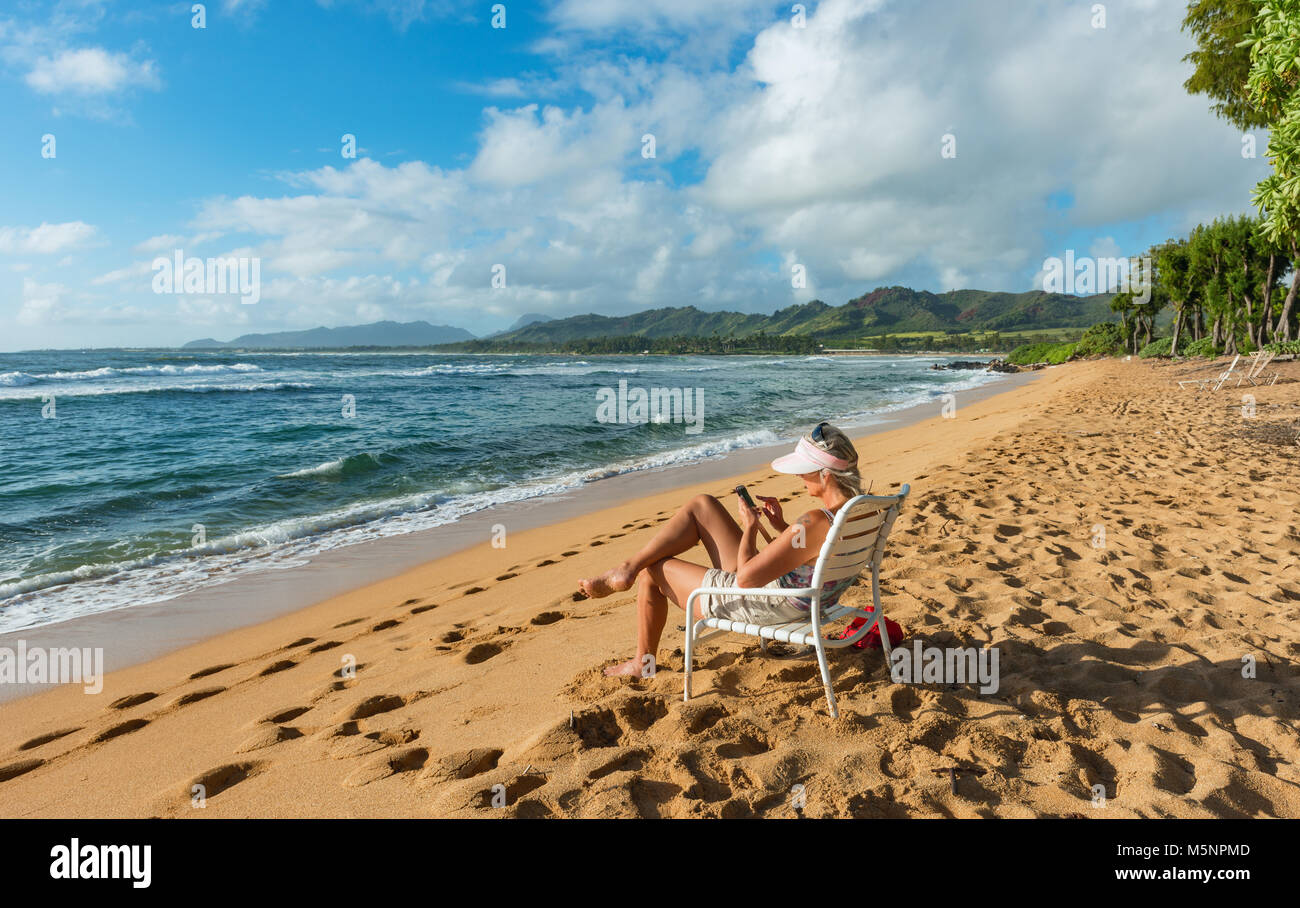 MAUI, HAWAII, USA-DECEMBER 20, 2013: Female tourist relaxing on a beach ...
