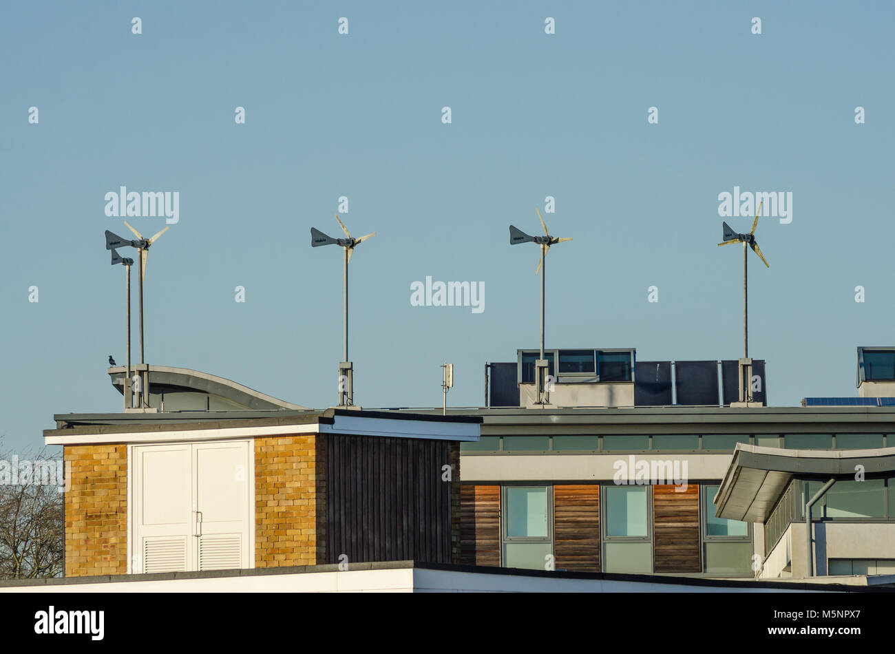 Small wind turbines on the roof of a building generate electricity to ...