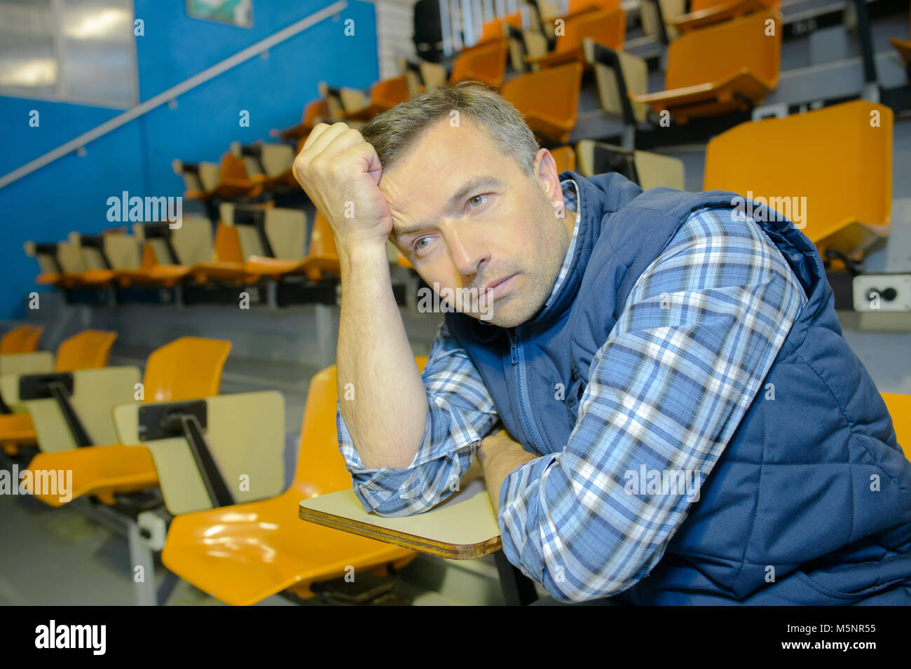 Man in auditorium looking fed up Stock Photo - Alamy