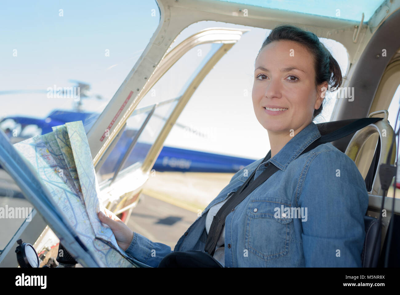 young woman helicopter pilot reading map Stock Photo - Alamy