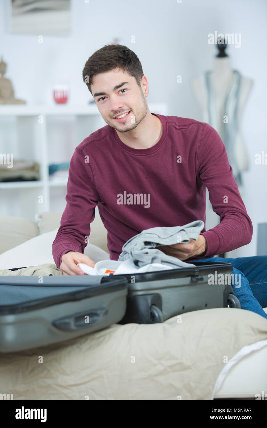 Portrait of man next to open suitcase Stock Photo - Alamy