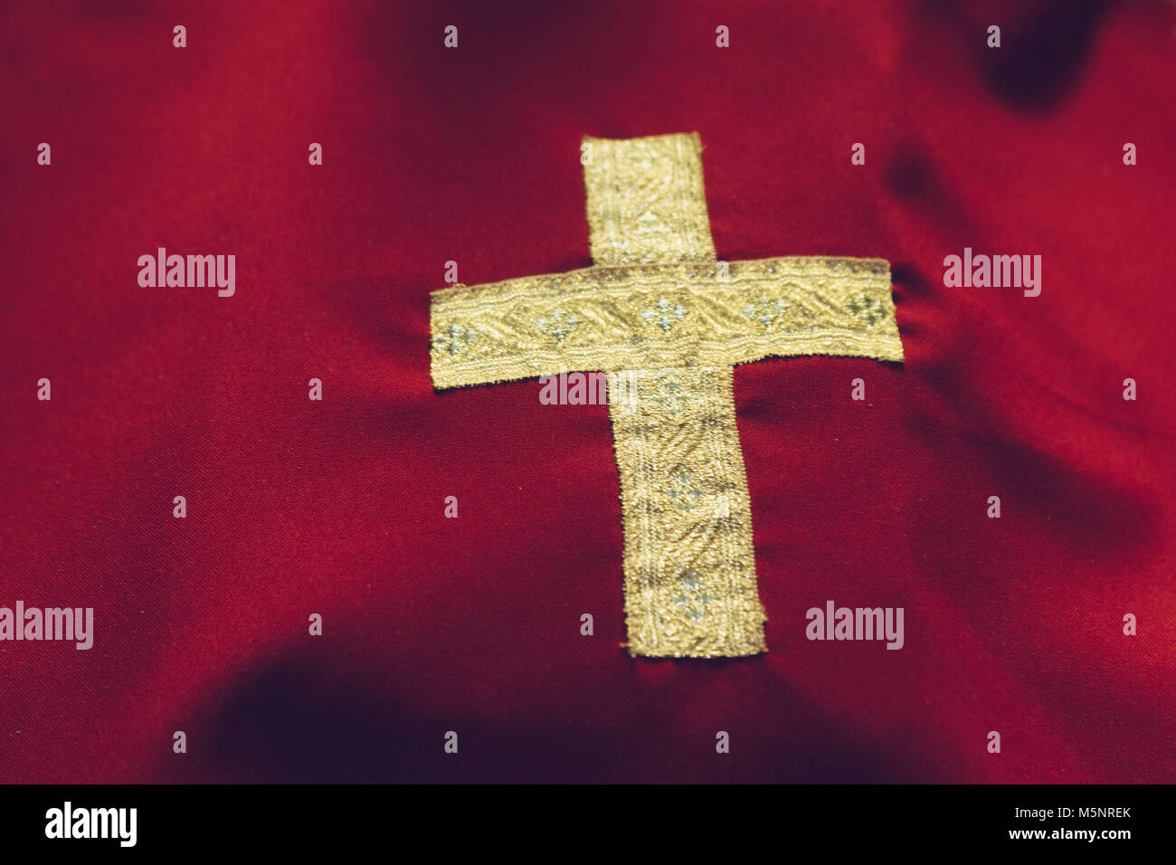 Gold cross on a red background Stock Photo - Alamy