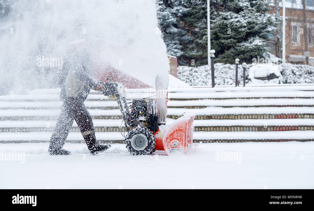 Snow-removal work with a snow blower. Man Removing Snow. heavy ...