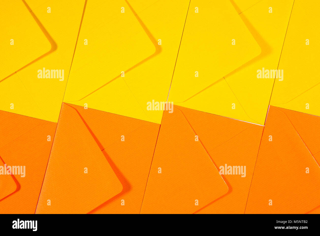 Pattern from orange and yellow envelopes on the table Stock Photo - Alamy