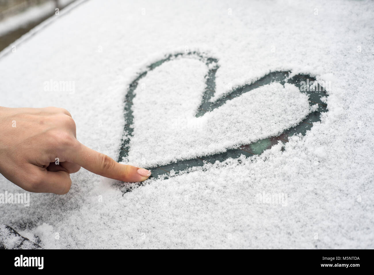 Heart drawn on a car windshield covered with fresh snow, close up Stock ...