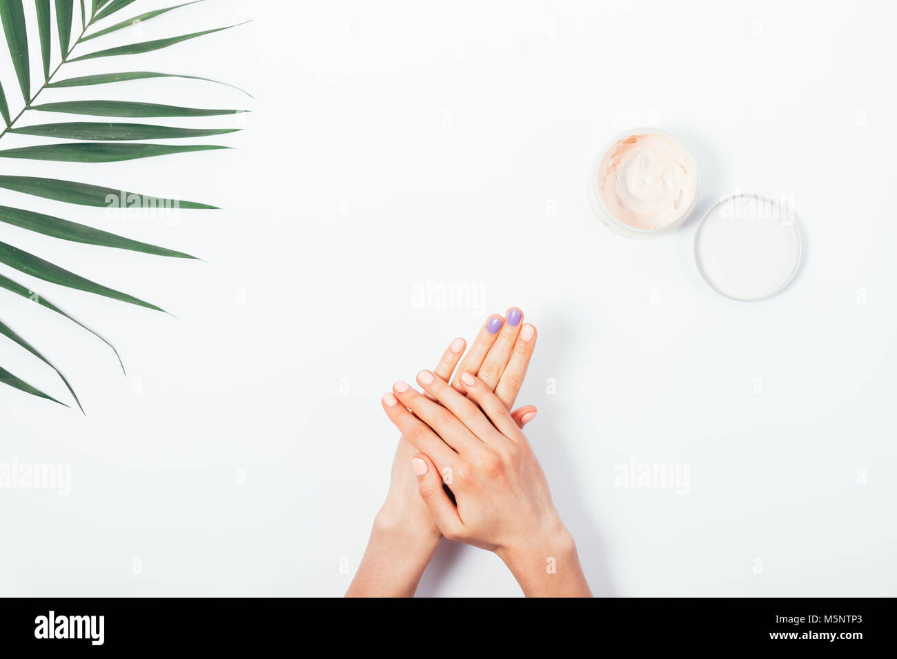 Woman rubbing cream on hand on white background top view Stock Photo ...